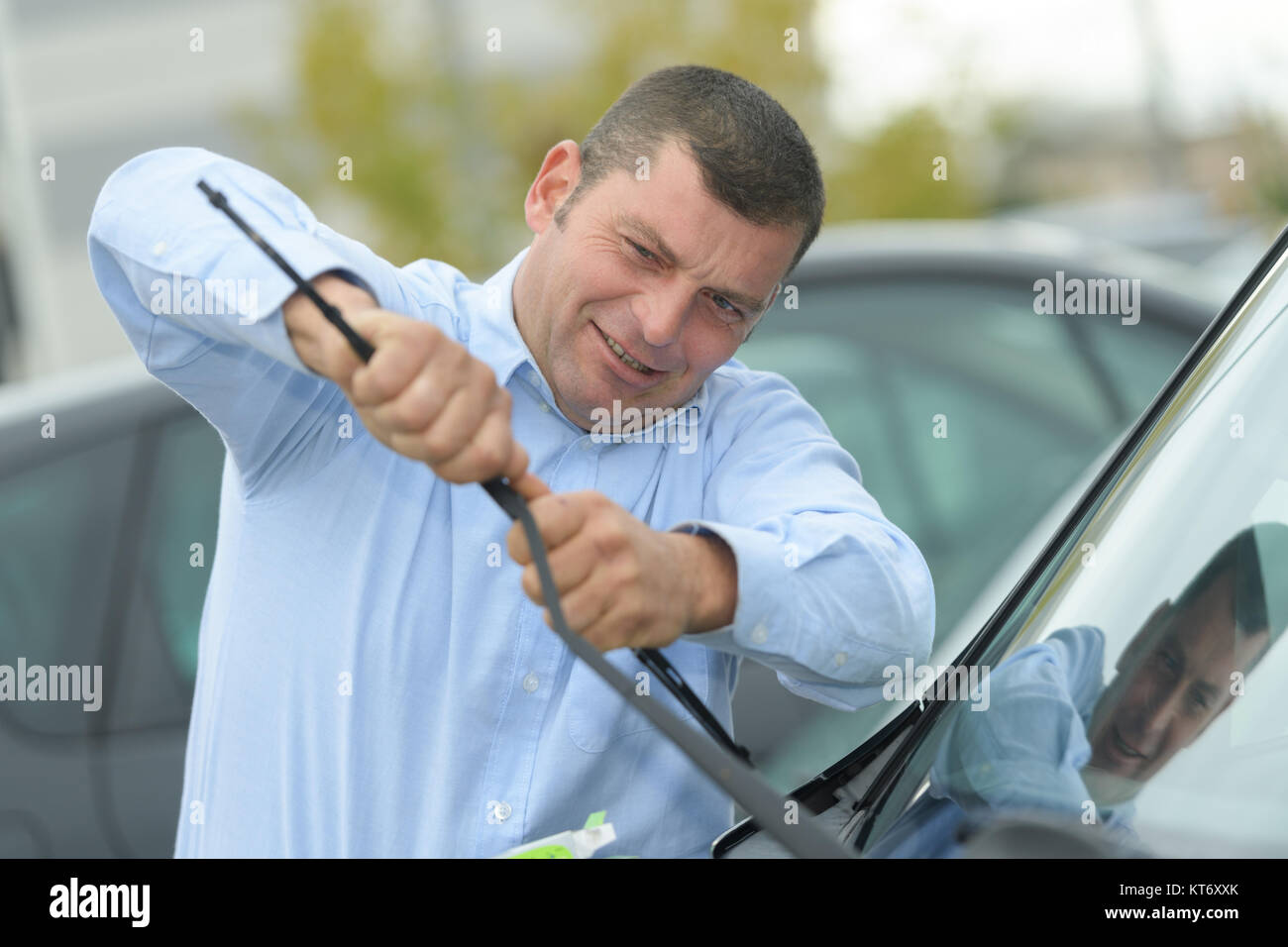 man picking up windscreen wiper Stock Photo - Alamy