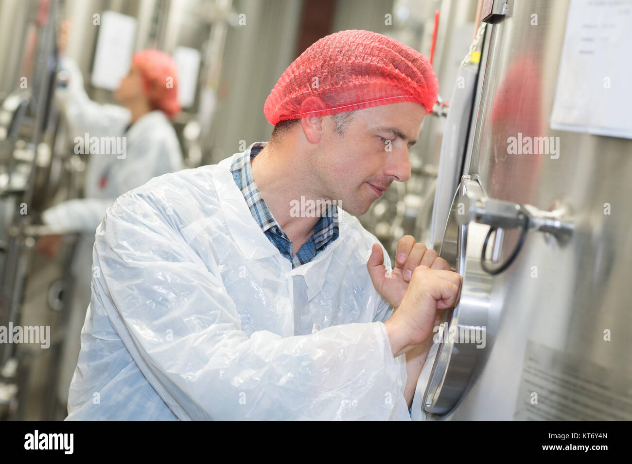 factory worker with metal vat Stock Photo - Alamy