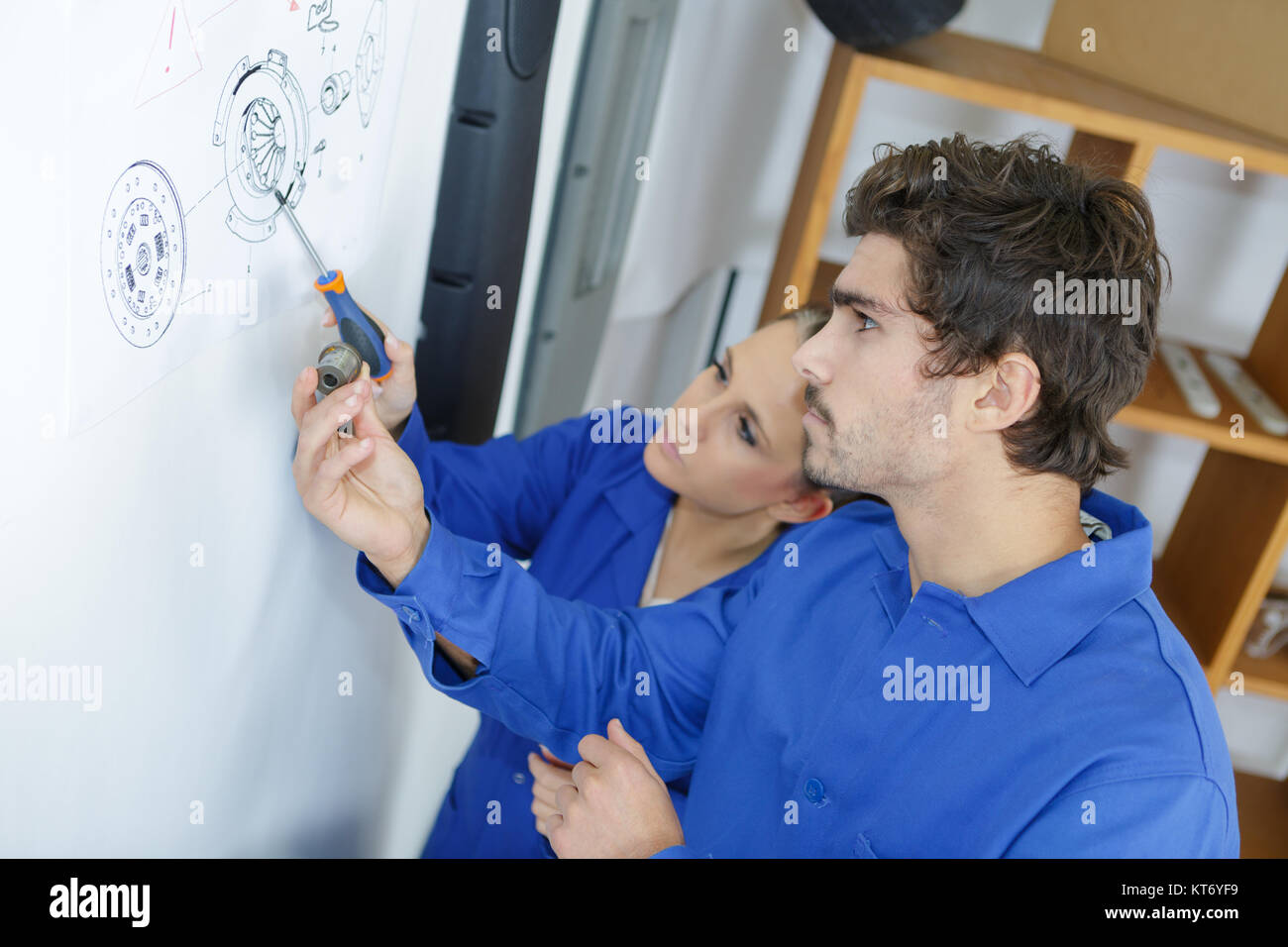 young engineer looking at drawing on board with colleague Stock Photo ...