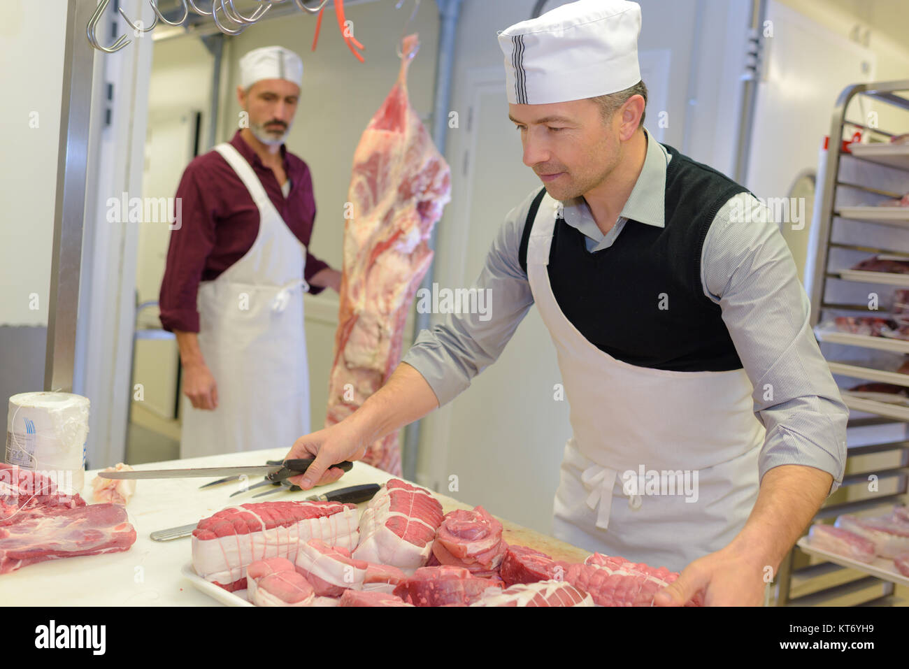 Butcher lifting tray of meat Stock Photo - Alamy