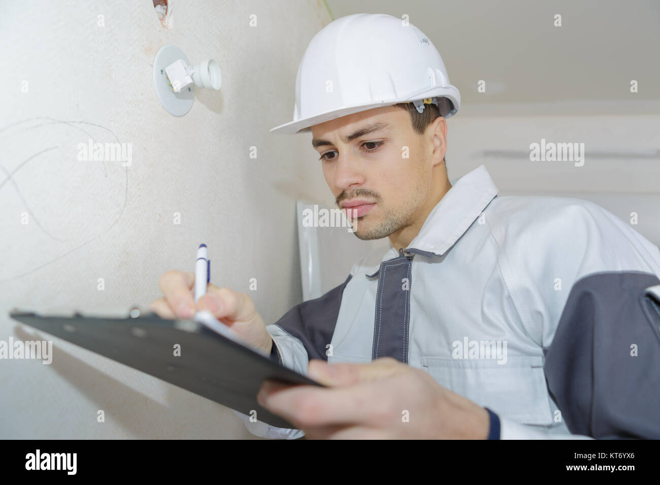 male engineer writing on clipboard at construction site Stock Photo - Alamy