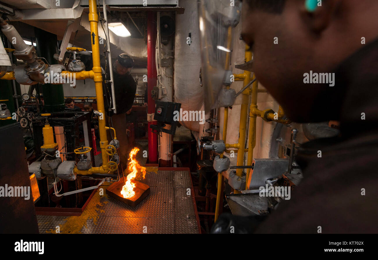 Commanding Officer, Capt. Andrew Smith lights off a boiler aboard the ...