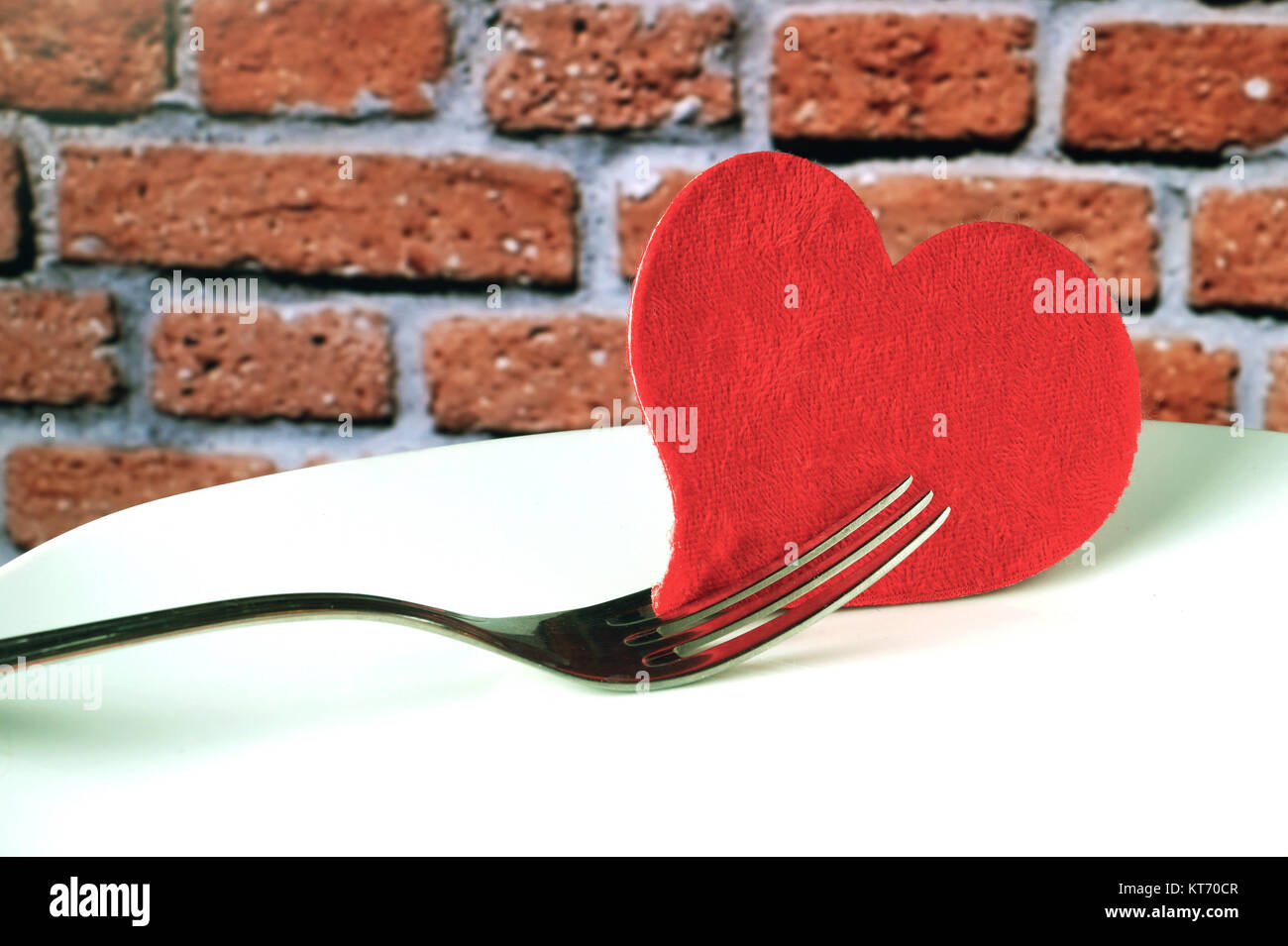 plate in shape of heart, table knife and fork on red background Stock ...