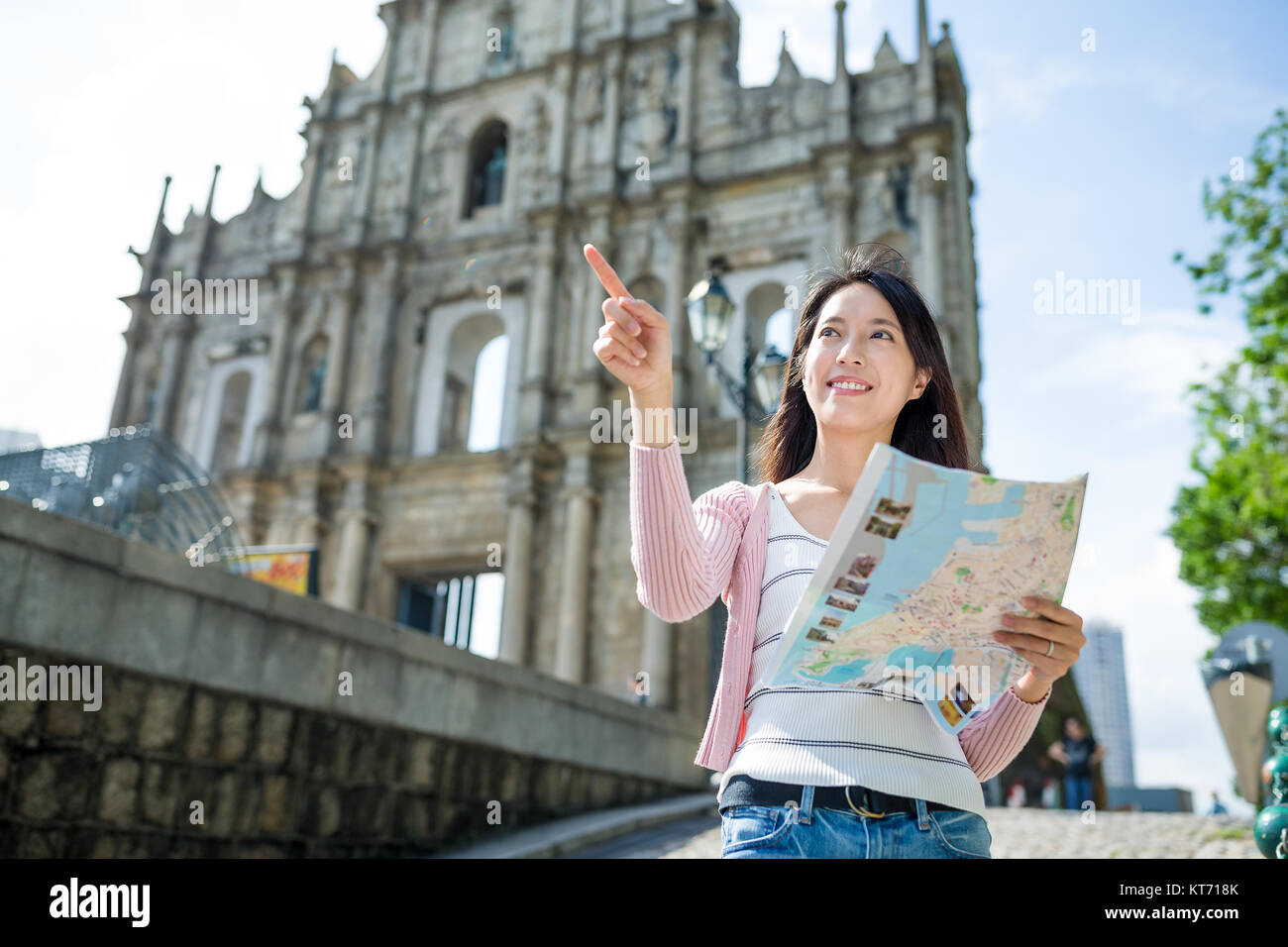 Woman using paper map in Macao city Stock Photo - Alamy