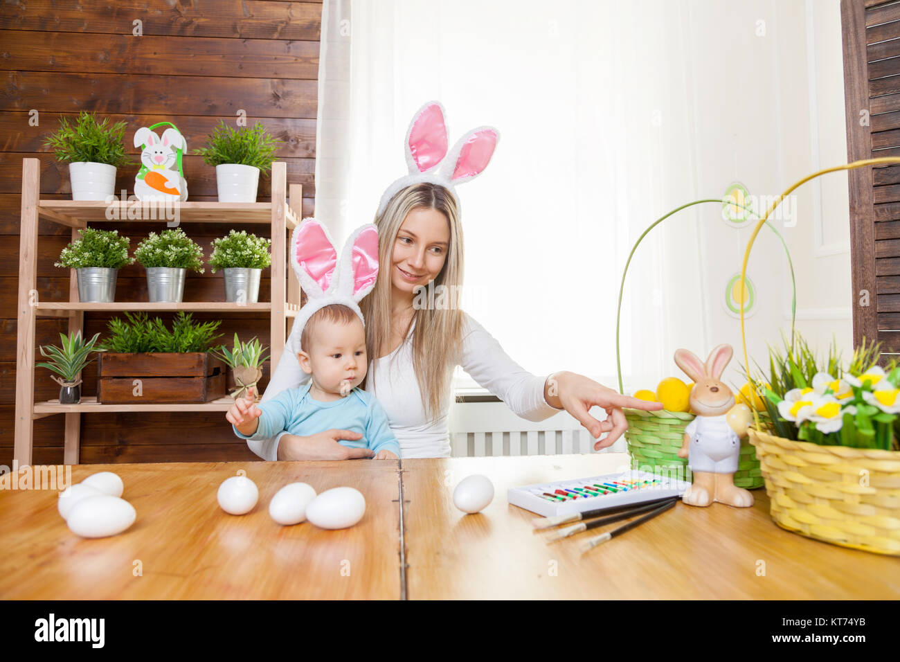 Happy mother and her cute child wearing bunny ears, getting ready for ...