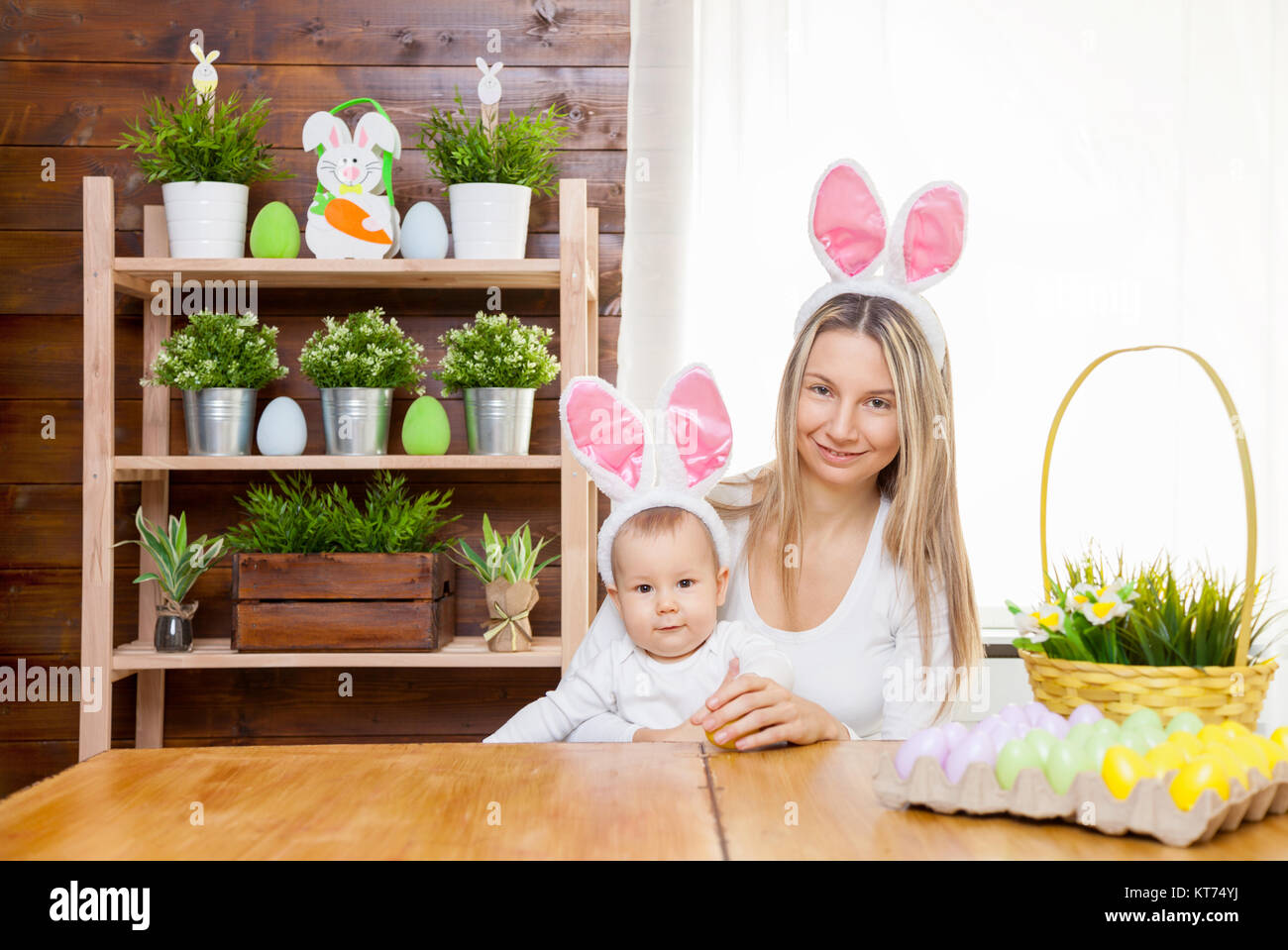 Happy mother and her cute child wearing bunny ears, getting ready for ...