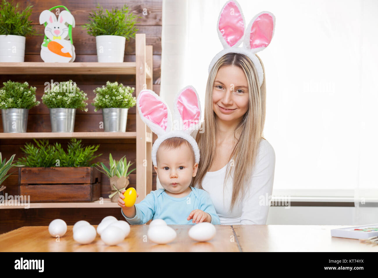 Happy mother and her cute child wearing bunny ears, getting ready for ...