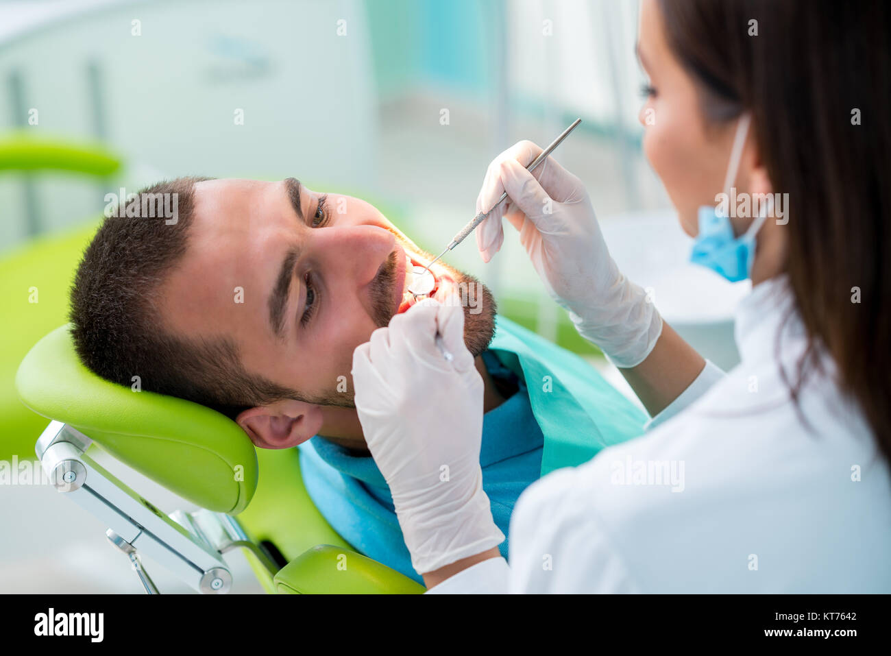 Dentist examining a patient's teeth in the dentist Stock Photo - Alamy