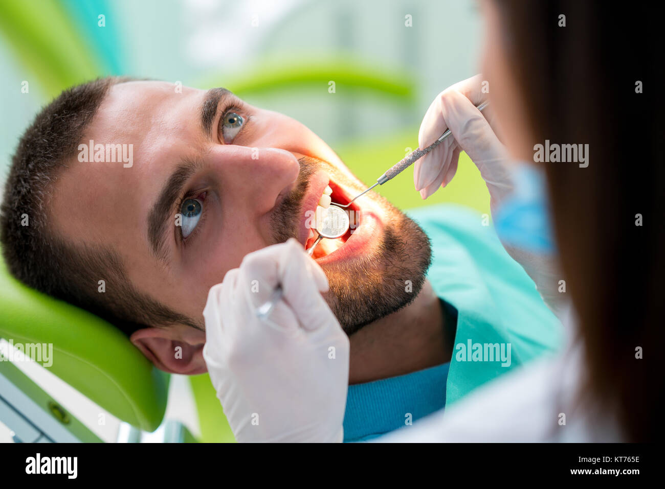 Dentist examining a patient's teeth in the dentist Stock Photo - Alamy