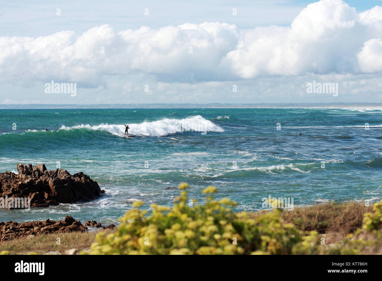 big wave surfer in scenic landscape with rocks Stock Photo - Alamy