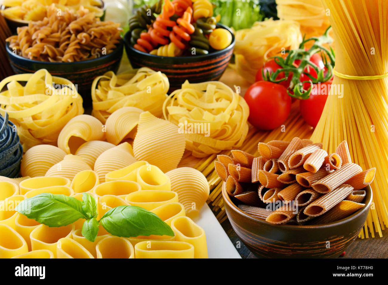Composition with different sorts of pasta on kitchen table Stock Photo ...