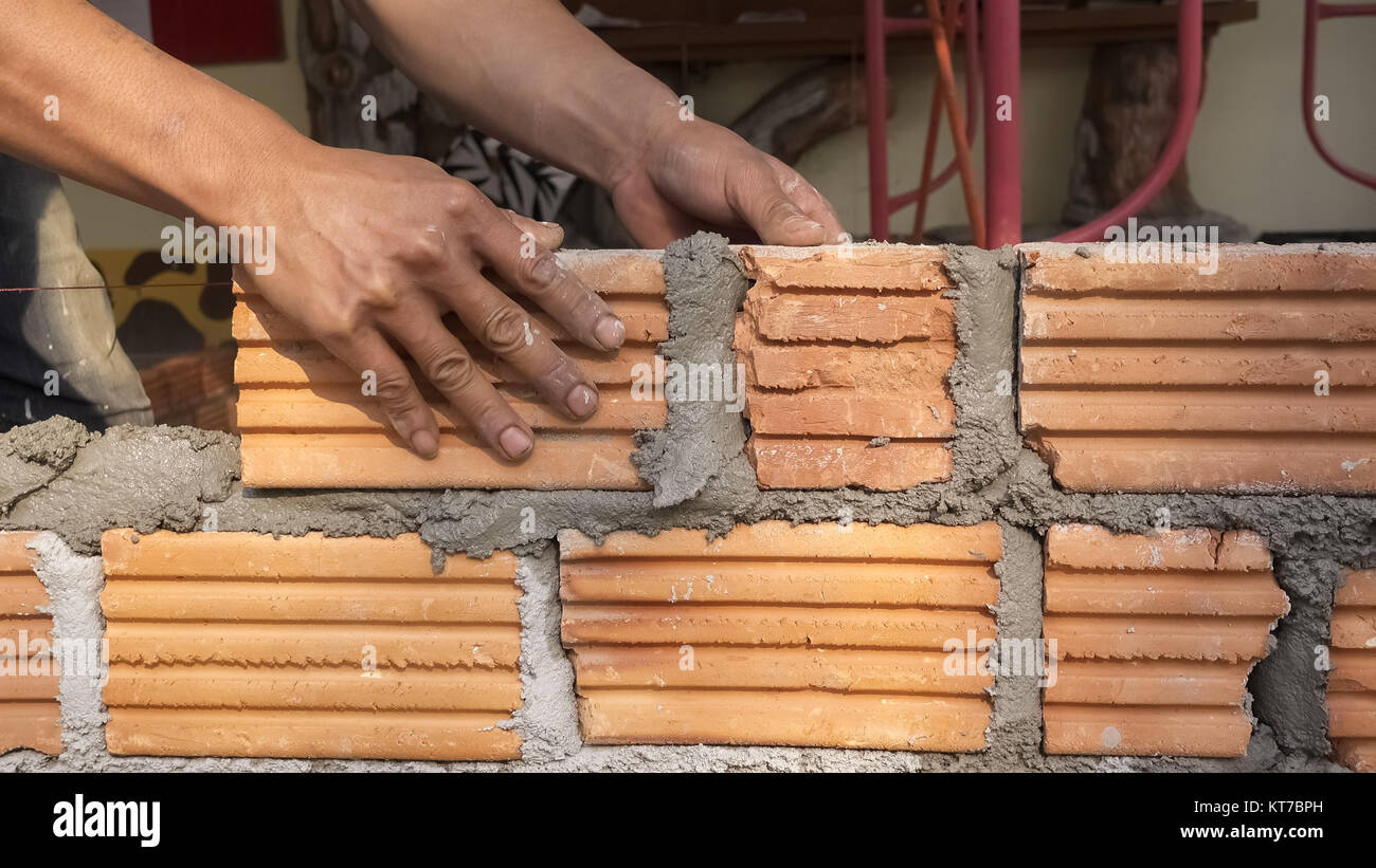 Bricklayer worker installing brick masonry on exterior wall Stock Photo ...