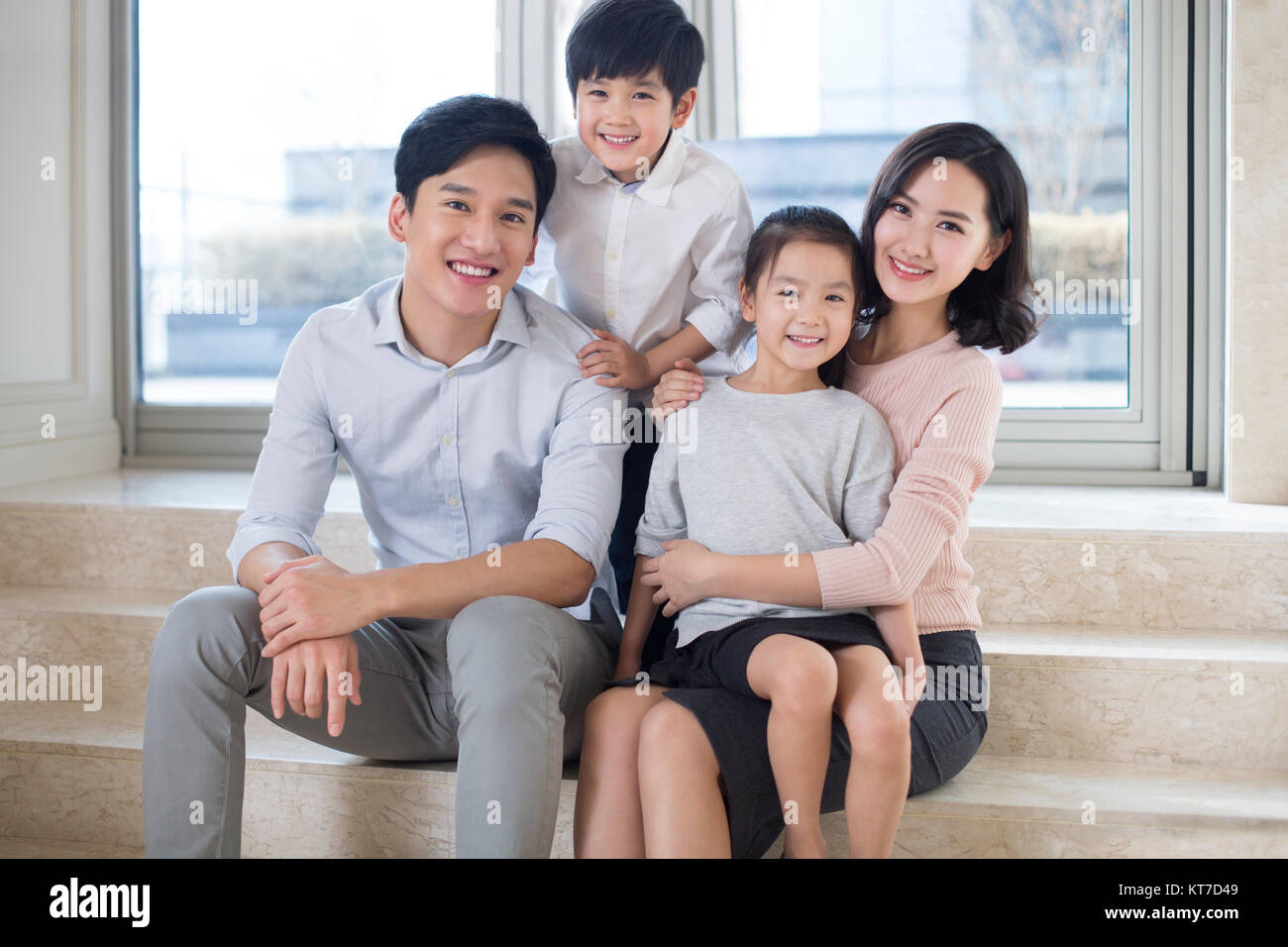 Portrait of cheerful young family in the living room Stock Photo - Alamy