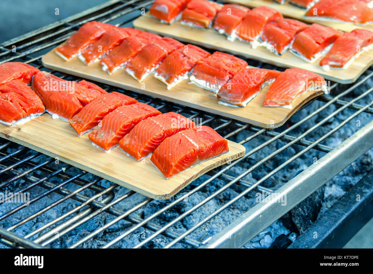 Fillet of red fish on wooden tabs over burning coals, on a grill Stock ...