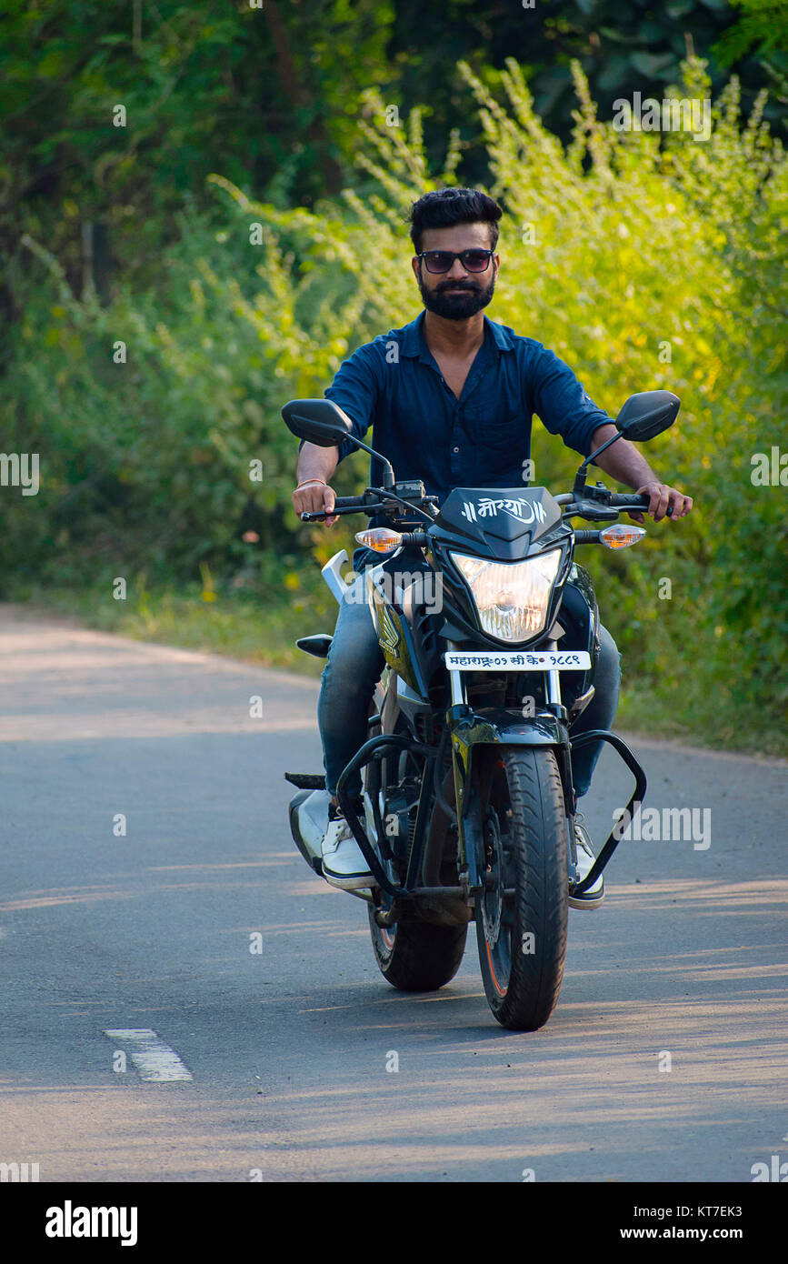 Young man riding bike on road Stock Photo - Alamy
