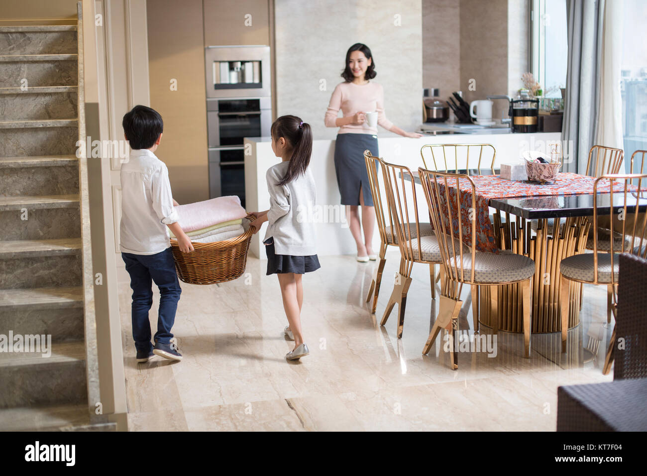 Happy siblings doing laundry at home Stock Photo - Alamy