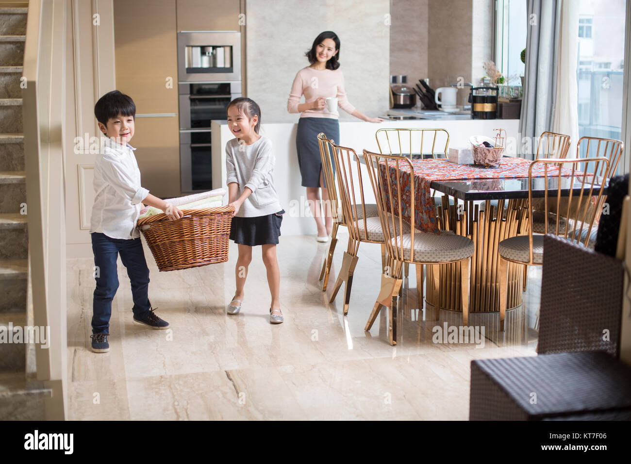 Happy siblings doing laundry at home Stock Photo - Alamy