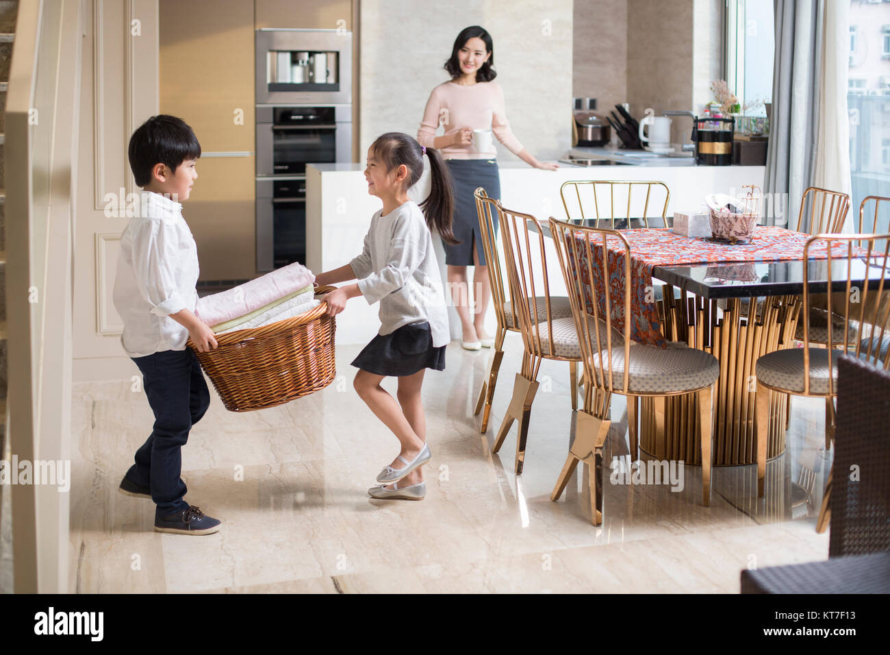 Happy siblings doing laundry at home Stock Photo - Alamy