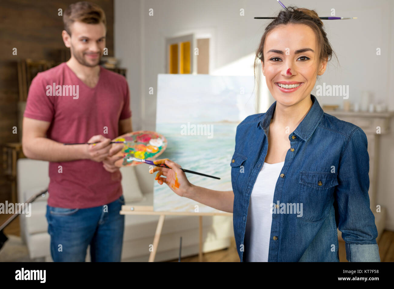 Happy young couple of artists painting together at home Stock Photo - Alamy