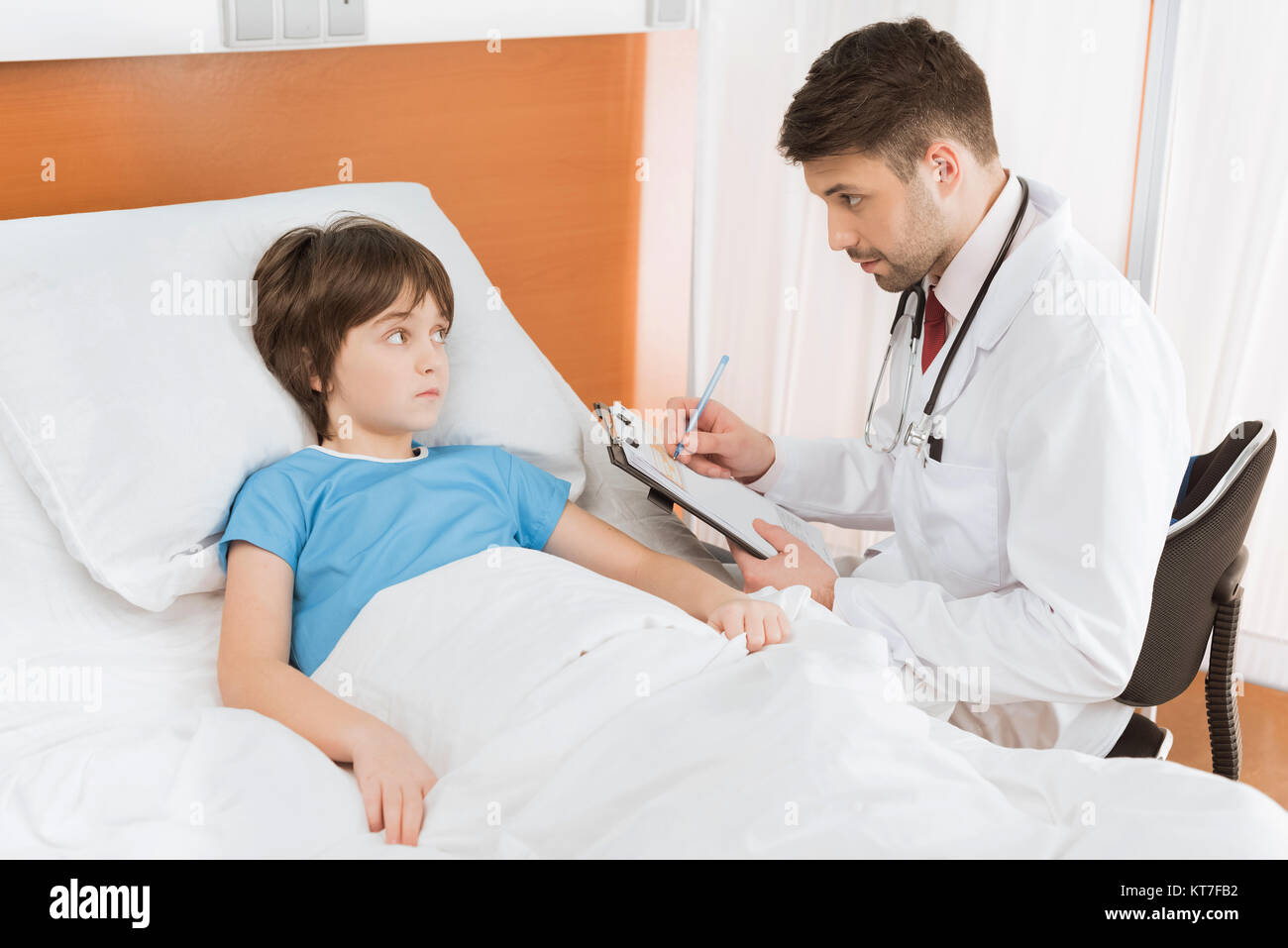 doctor writing down child patient's symptoms in hospital Stock Photo ...