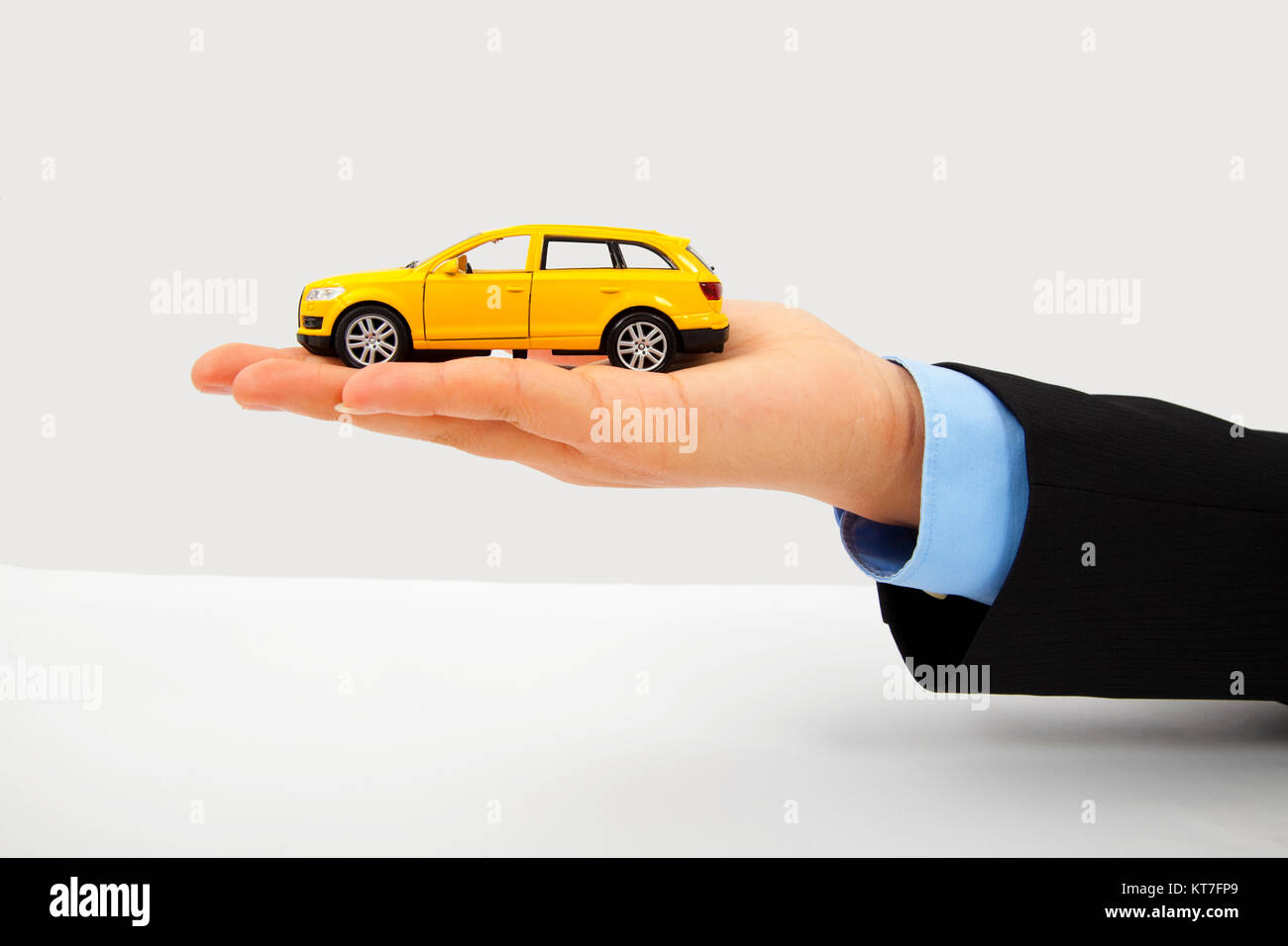 Businessman's hand holding a car Stock Photo - Alamy