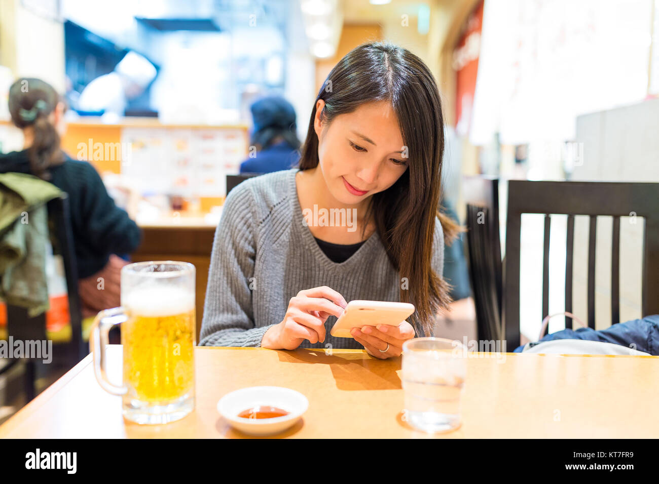 Woman use of cellphone in restaurant Stock Photo - Alamy