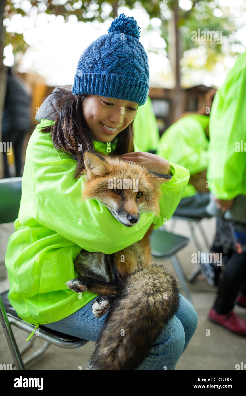 Young woman hugging fox Stock Photo - Alamy