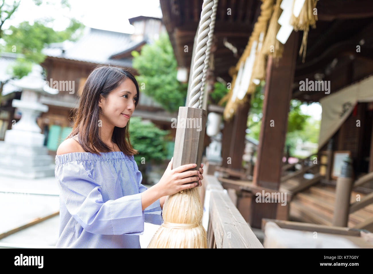Woman ringing the bell in Japanese temple Stock Photo - Alamy
