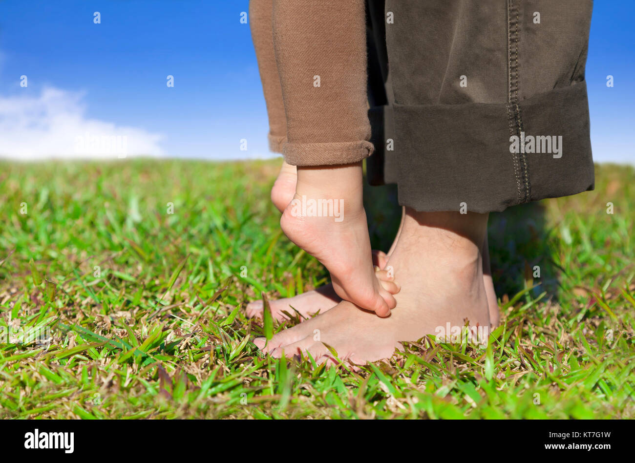 Family feet on the grass with cloud background Stock Photo - Alamy