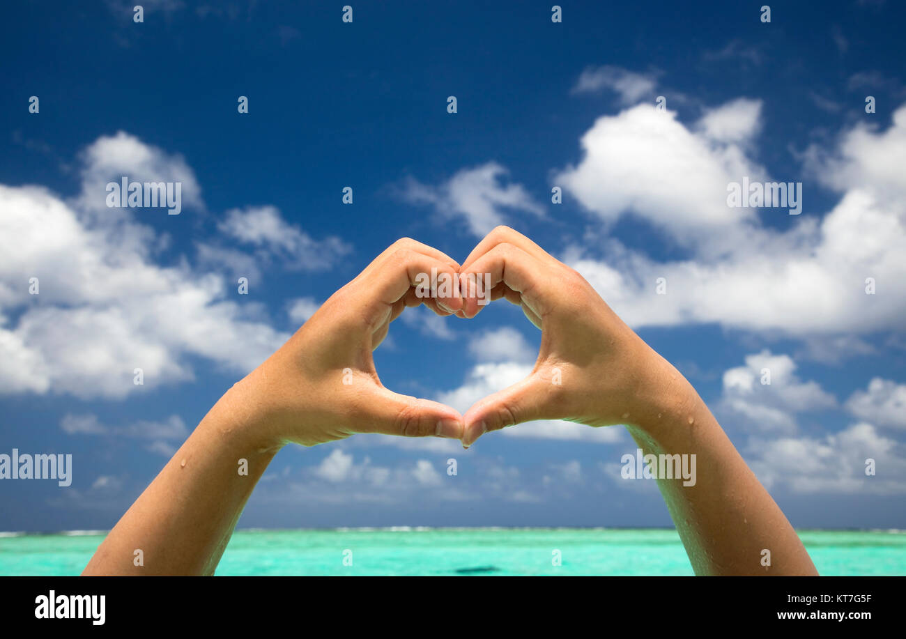 hand forming a heart on tropical beach background Stock Photo - Alamy
