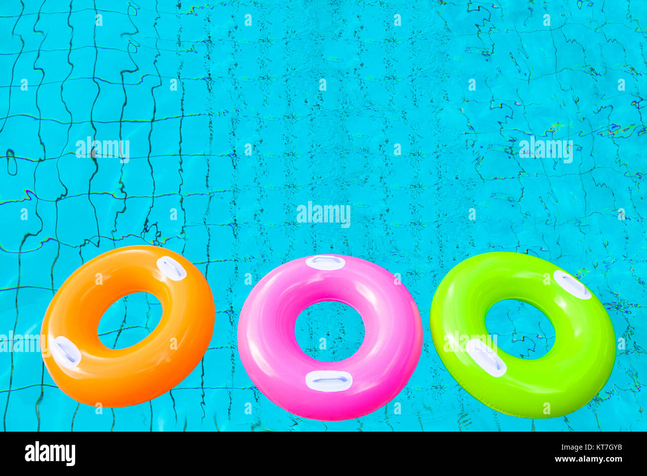 three colorful swimming pool rings on the water Stock Photo - Alamy