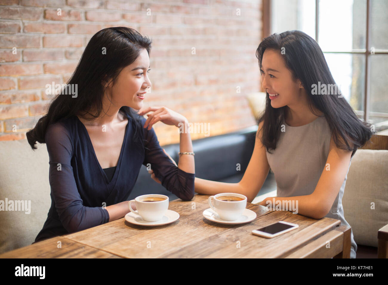 Best female friends drinking coffee in café Stock Photo - Alamy
