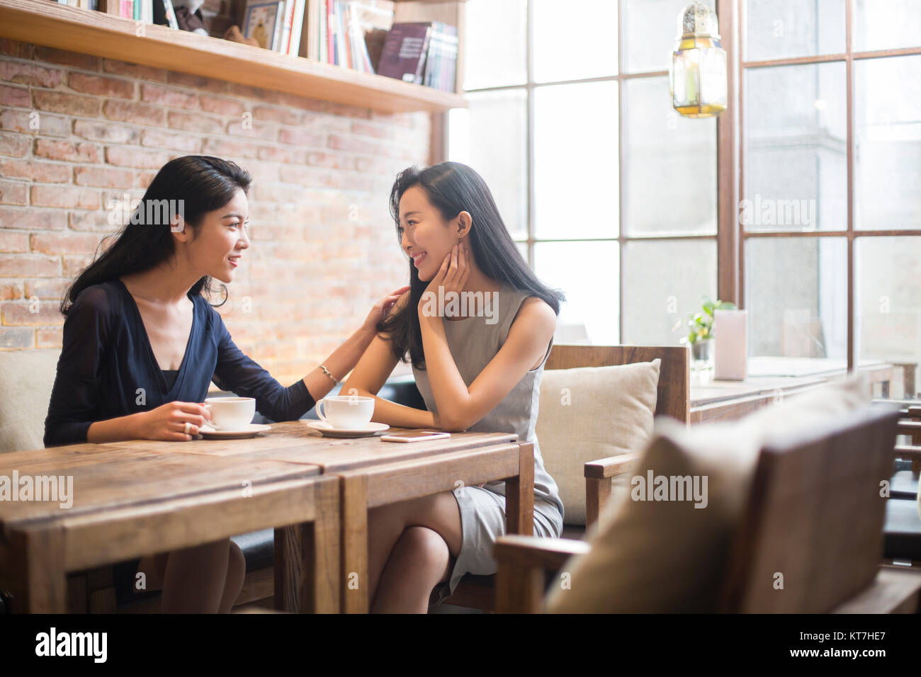 Best female friends drinking coffee in café Stock Photo - Alamy