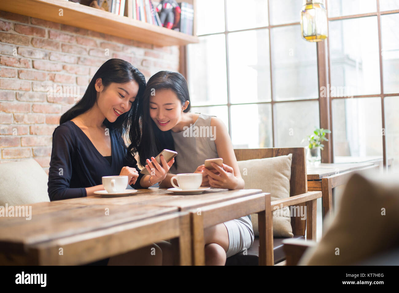 Best female friends drinking coffee in café Stock Photo - Alamy