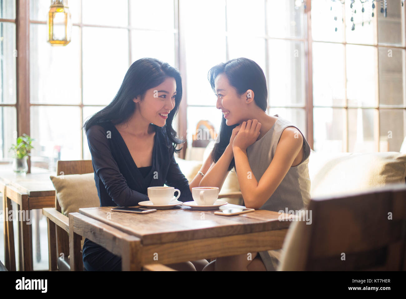 Best female friends drinking coffee in café Stock Photo - Alamy