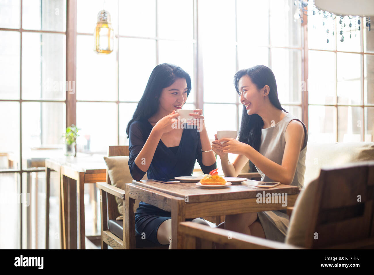 Best female friends drinking coffee in café Stock Photo - Alamy
