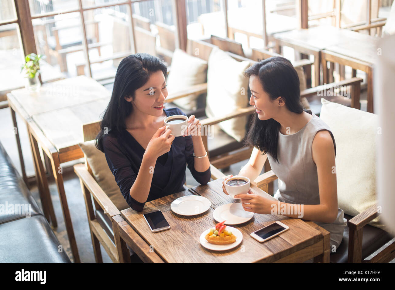 Best female friends drinking coffee in café Stock Photo - Alamy