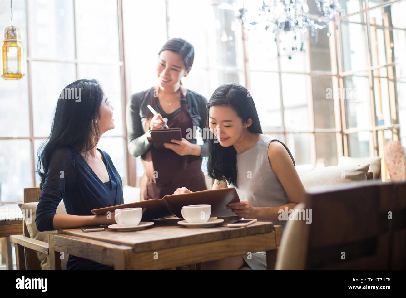 Best female friends drinking coffee in café Stock Photo - Alamy