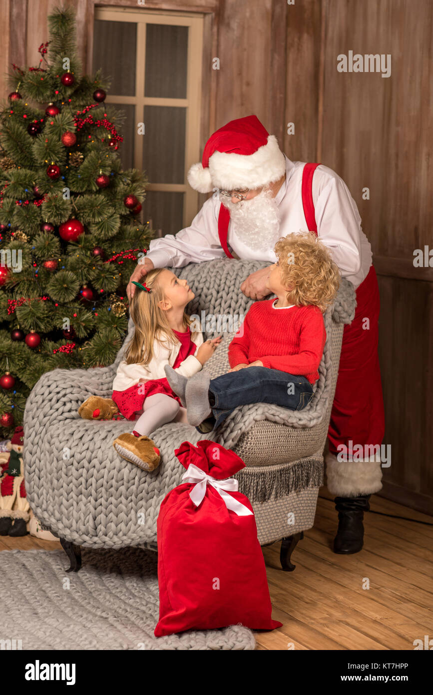 Happy children looking at Santa Claus Stock Photo - Alamy