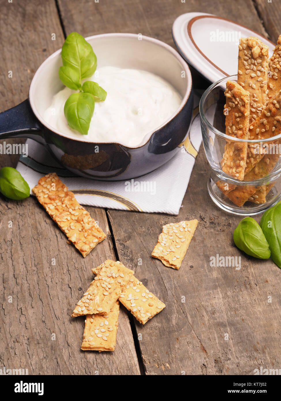 Organic cracker with sesame and a tasty garlic dip on a rustic wooden ...