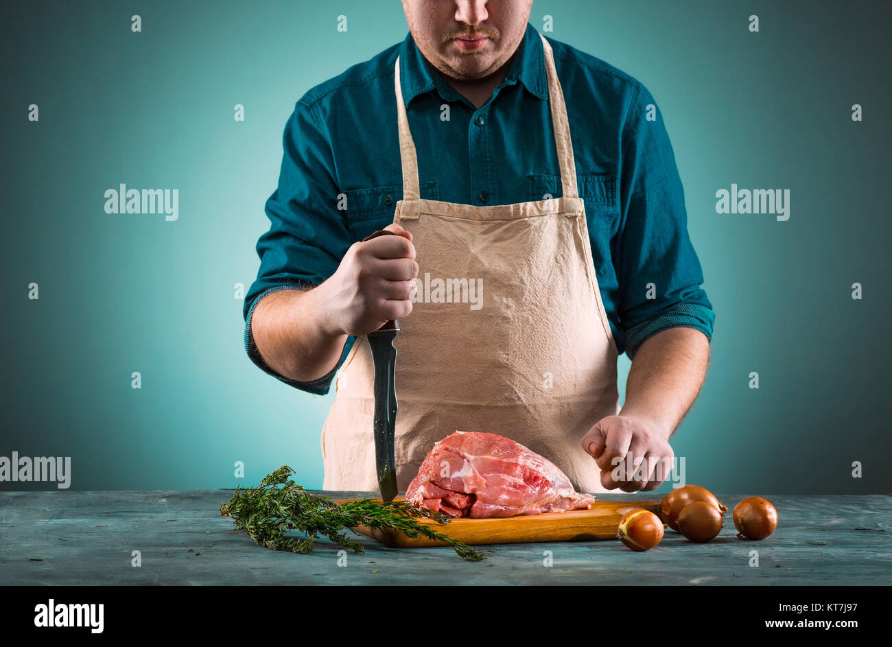 Butcher cutting pork meat on kitchen Stock Photo - Alamy