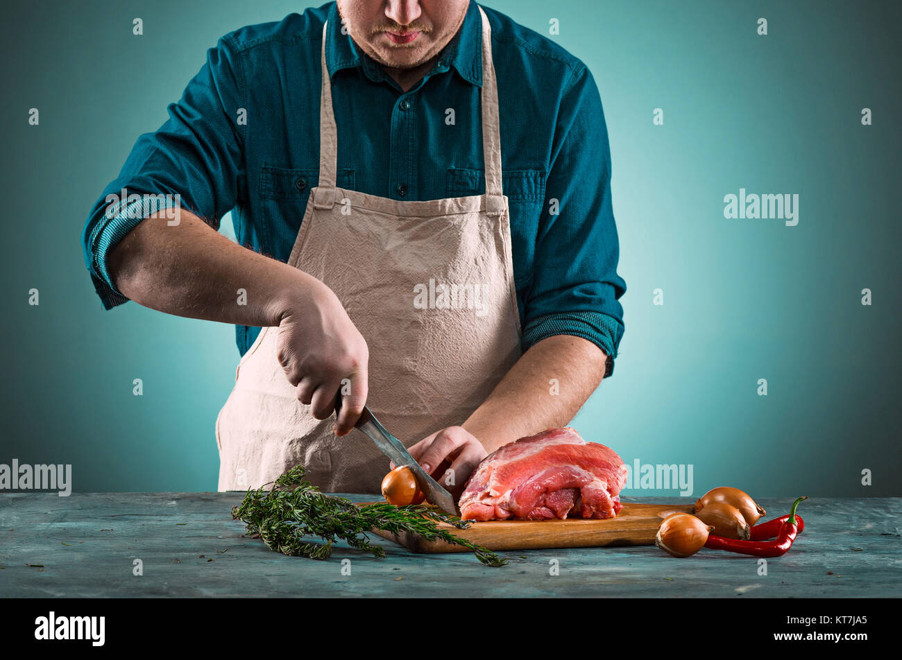 Butcher cutting pork meat on kitchen Stock Photo - Alamy