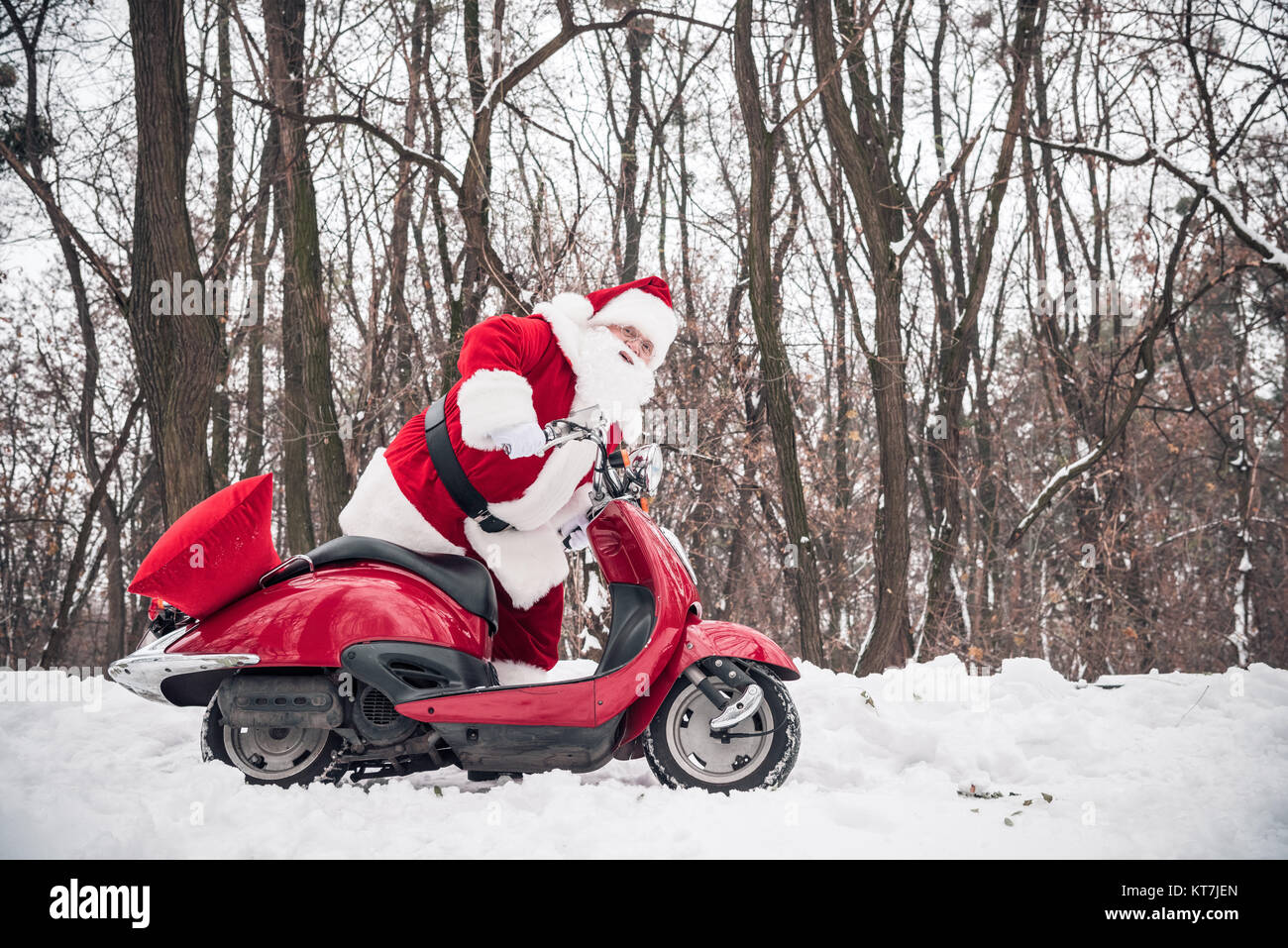 Santa Claus riding red scooter Stock Photo - Alamy