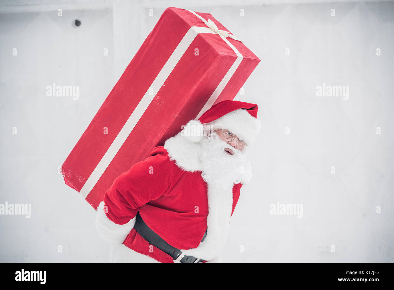 Santa Claus carrying gift box Stock Photo - Alamy