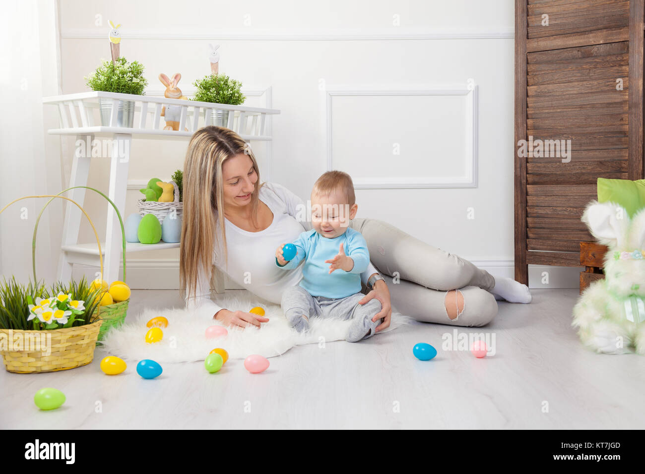 Delighted mother and her child enjoying the Easter egg hunt at home ...