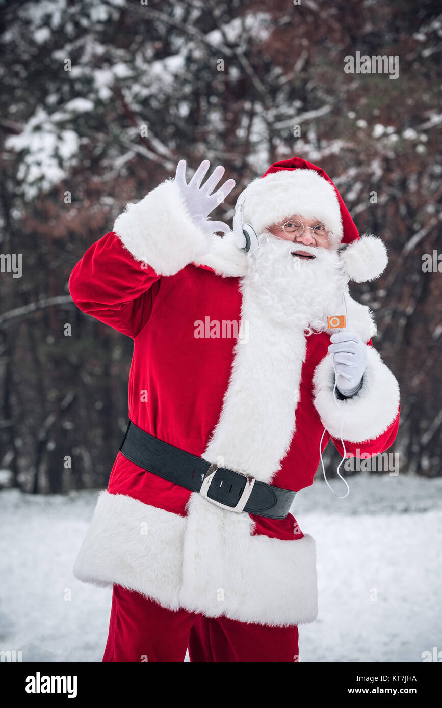 Santa Claus listening to music in headphones Stock Photo - Alamy
