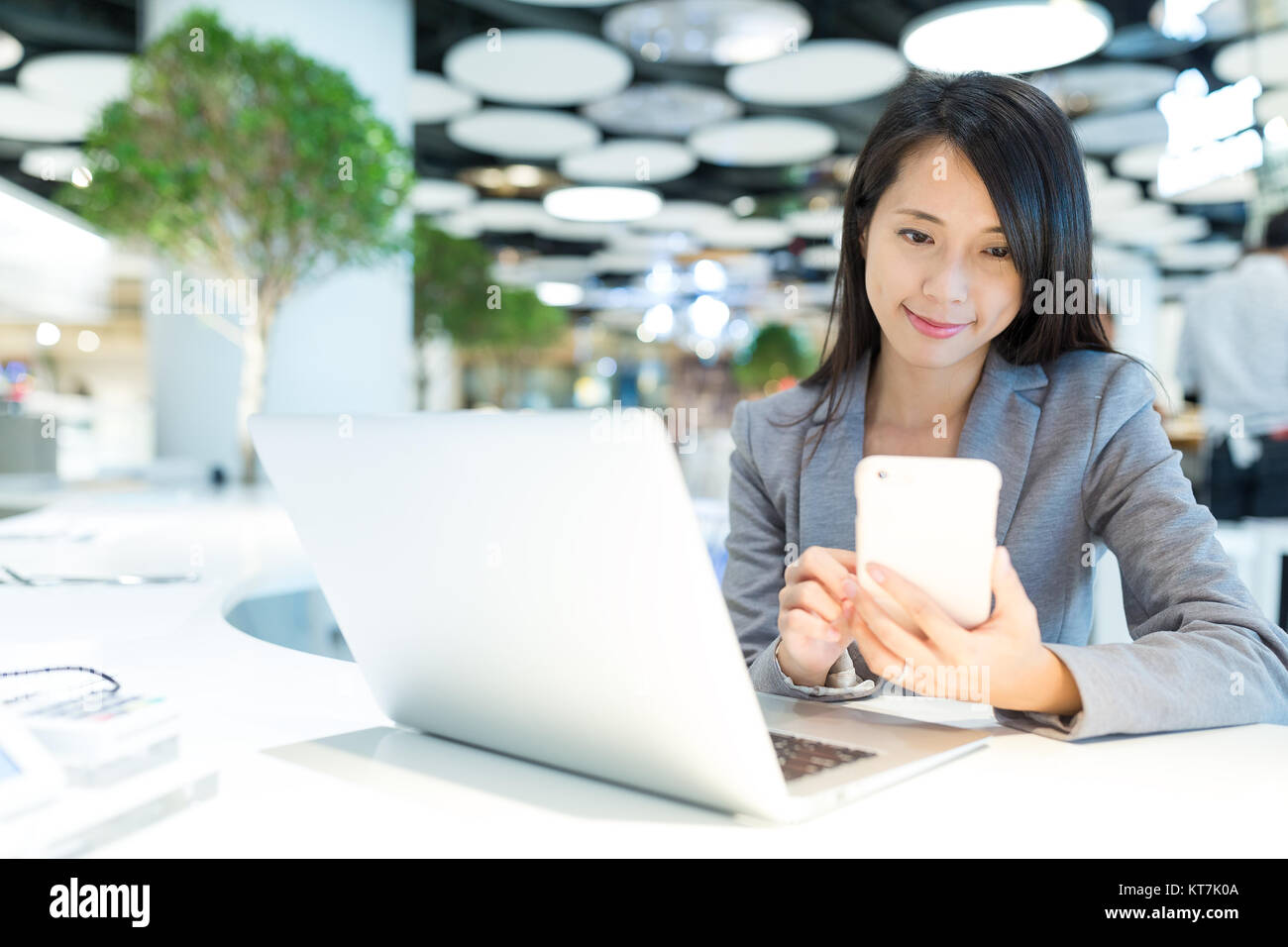 Woman use of cellphone and laptop computer Stock Photo - Alamy
