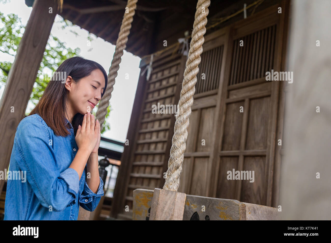 Woman wishes blessing in Japanese temple Stock Photo - Alamy