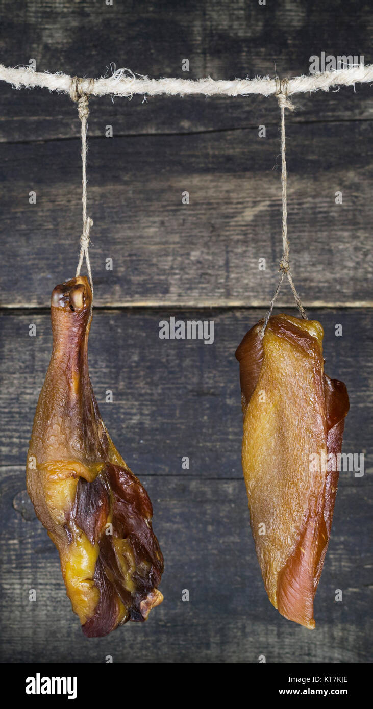 Smoked Chicken Leg Hanging on the Rope Against Wooden Background Stock ...