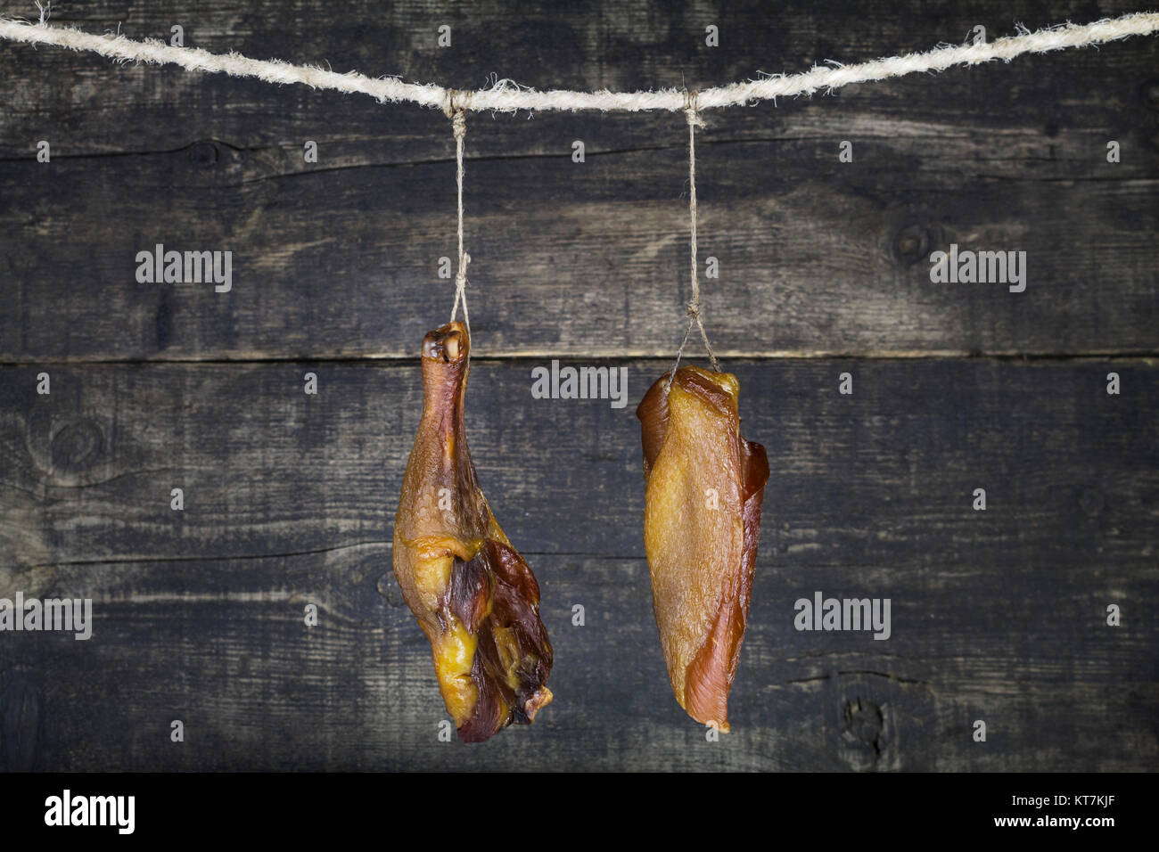 Smoked Chicken Leg Hanging on the Rope Against Wooden Background Stock ...